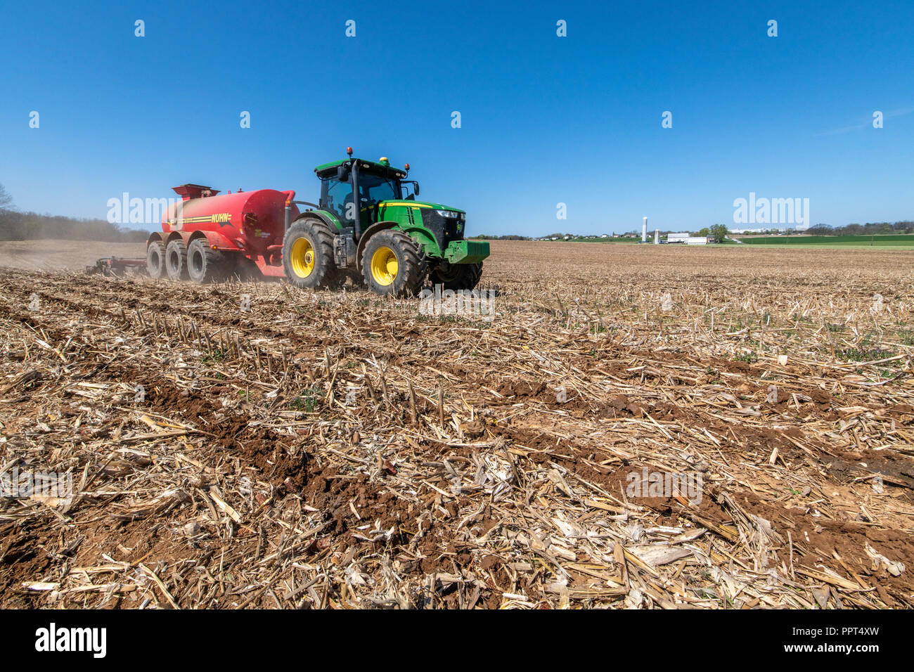A tractor driven tanker injects duck manure into corn stubble to help ...