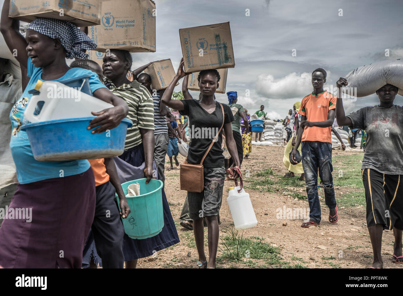 South Sudanese female refugees seen carrying palm oil on top of their heads as they were given ...