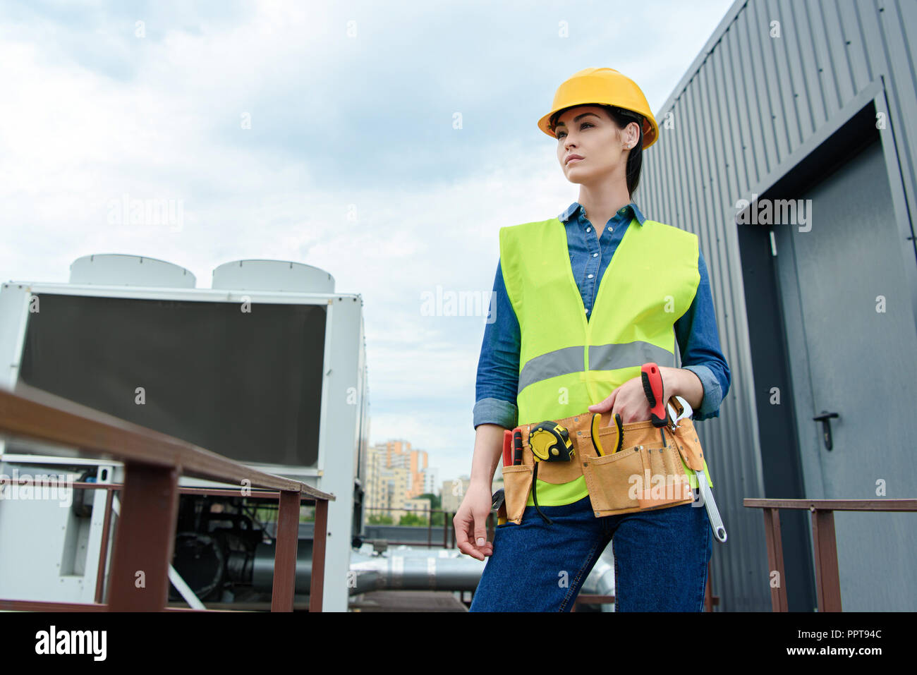 female engineer with tool belt posing in safety vest and hardhat Stock ...