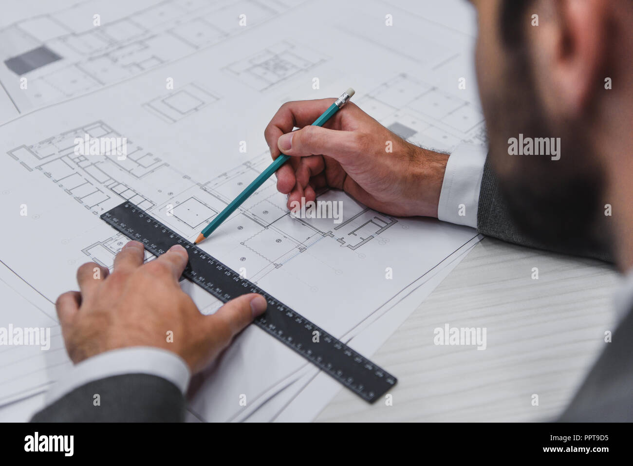 cropped view of architect working with blueprints, pencil and ruler ...