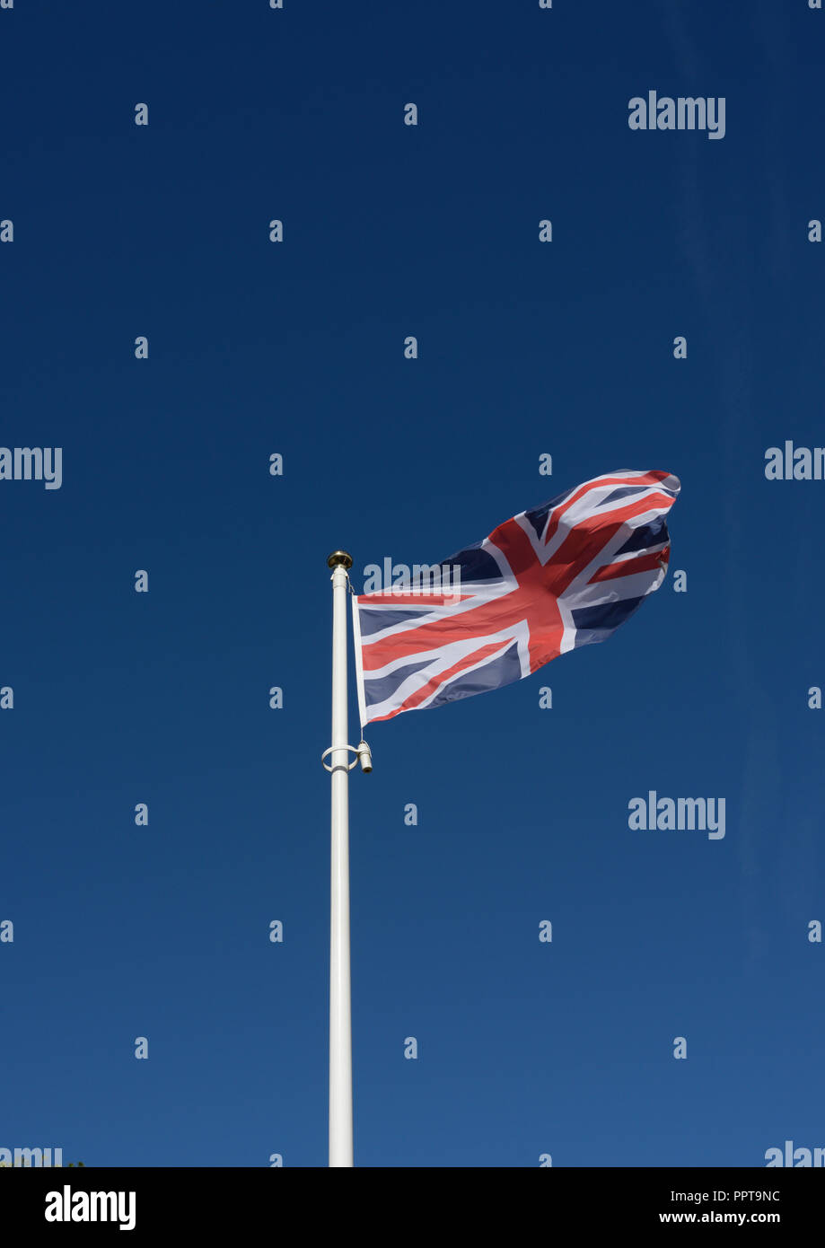 Union jack flag fluttering in the wind in a clear blue sky in bury ...