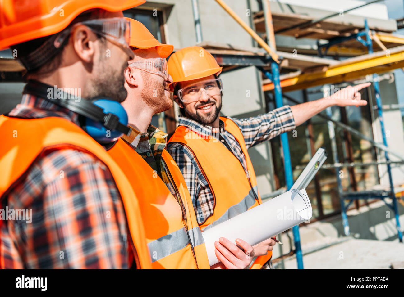 close-up shot of group of equipped builders looking away at ...