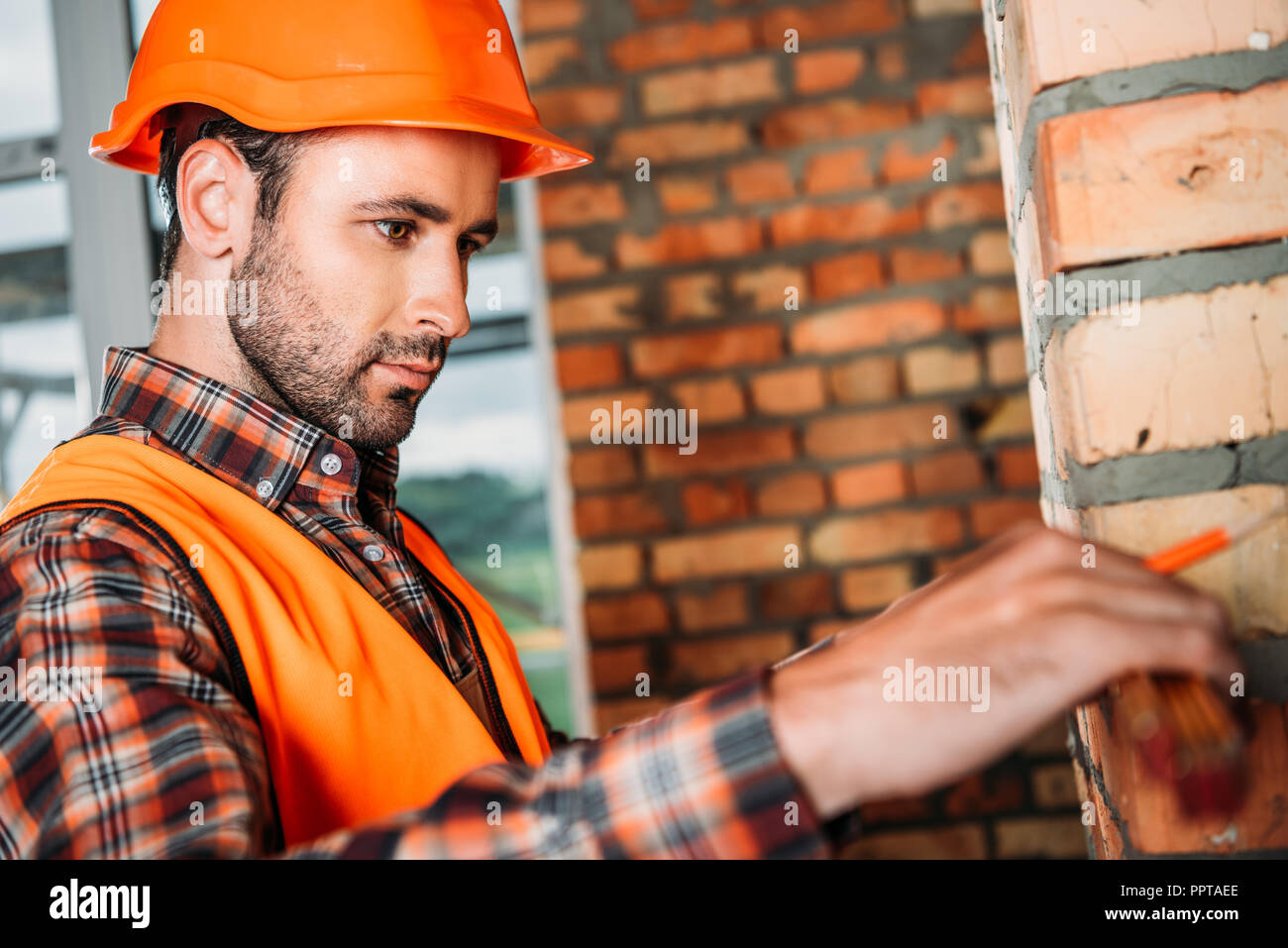 handsome young builder doing measurements at construction site Stock ...