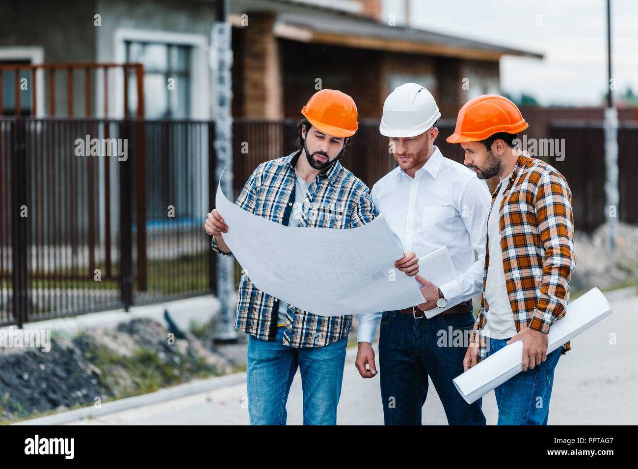 group of architects standing on building street with blueprints Stock ...