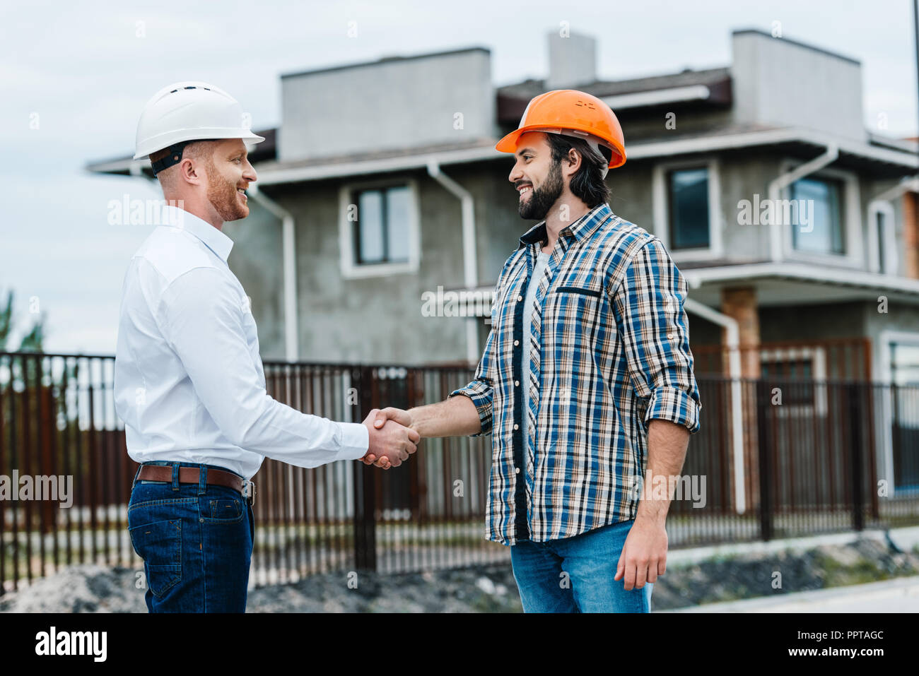 handsome architects shaking hands at construction site Stock Photo - Alamy