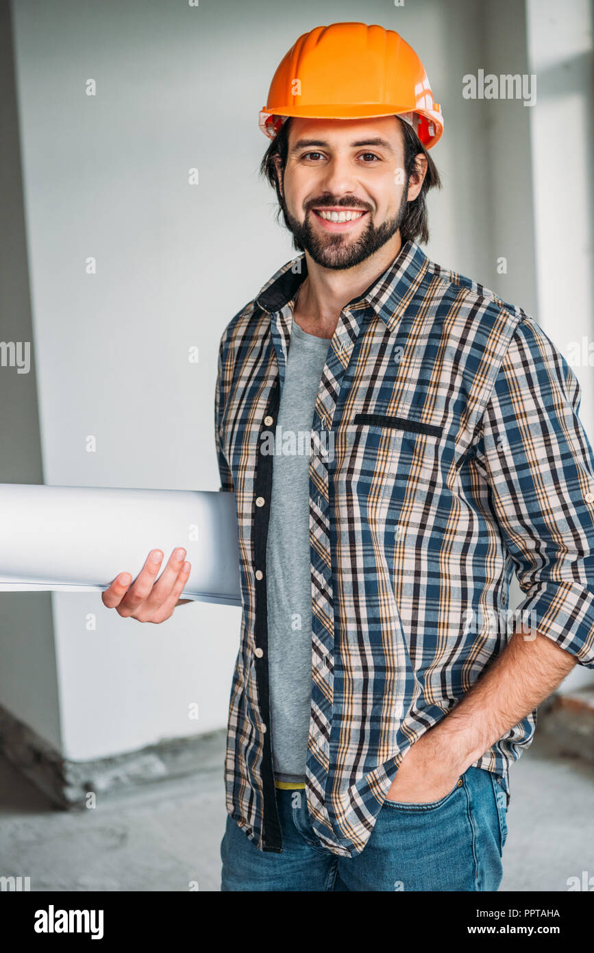 successful smiling architect in plaid shirt and hard hat standing ...