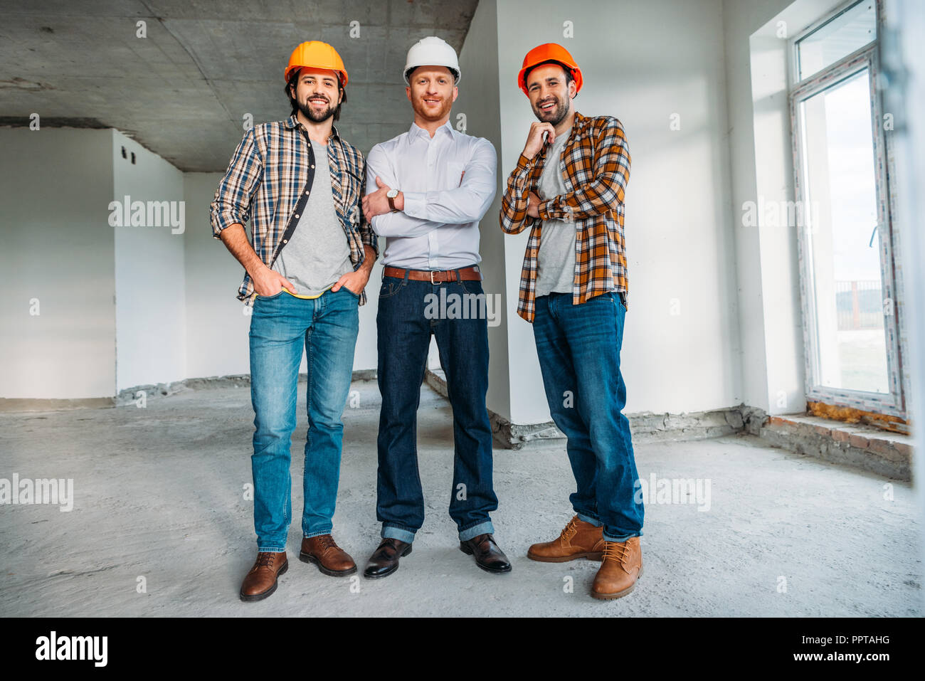 group of architects inside of constructing building looking at camera Stock Photo - Alamy