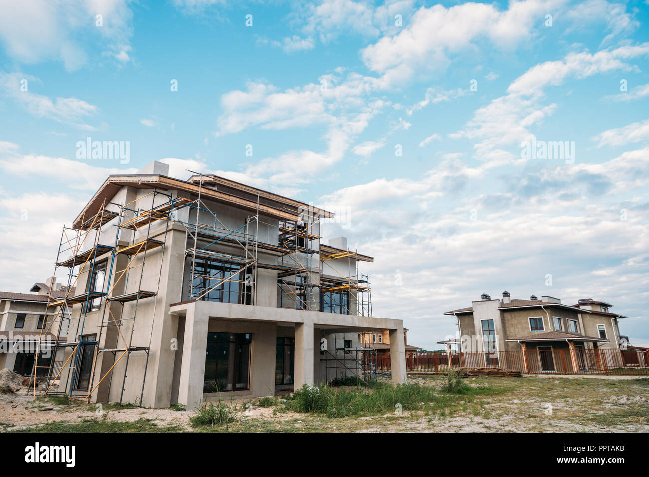 unfinished building construction with scaffolding under cloudy sky ...