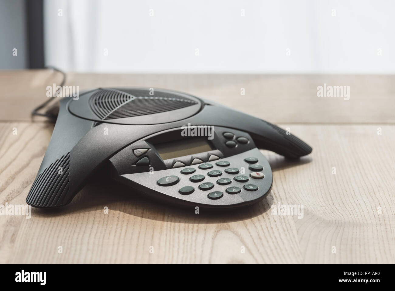 close-up shot of modern conference phone on wooden table at office ...