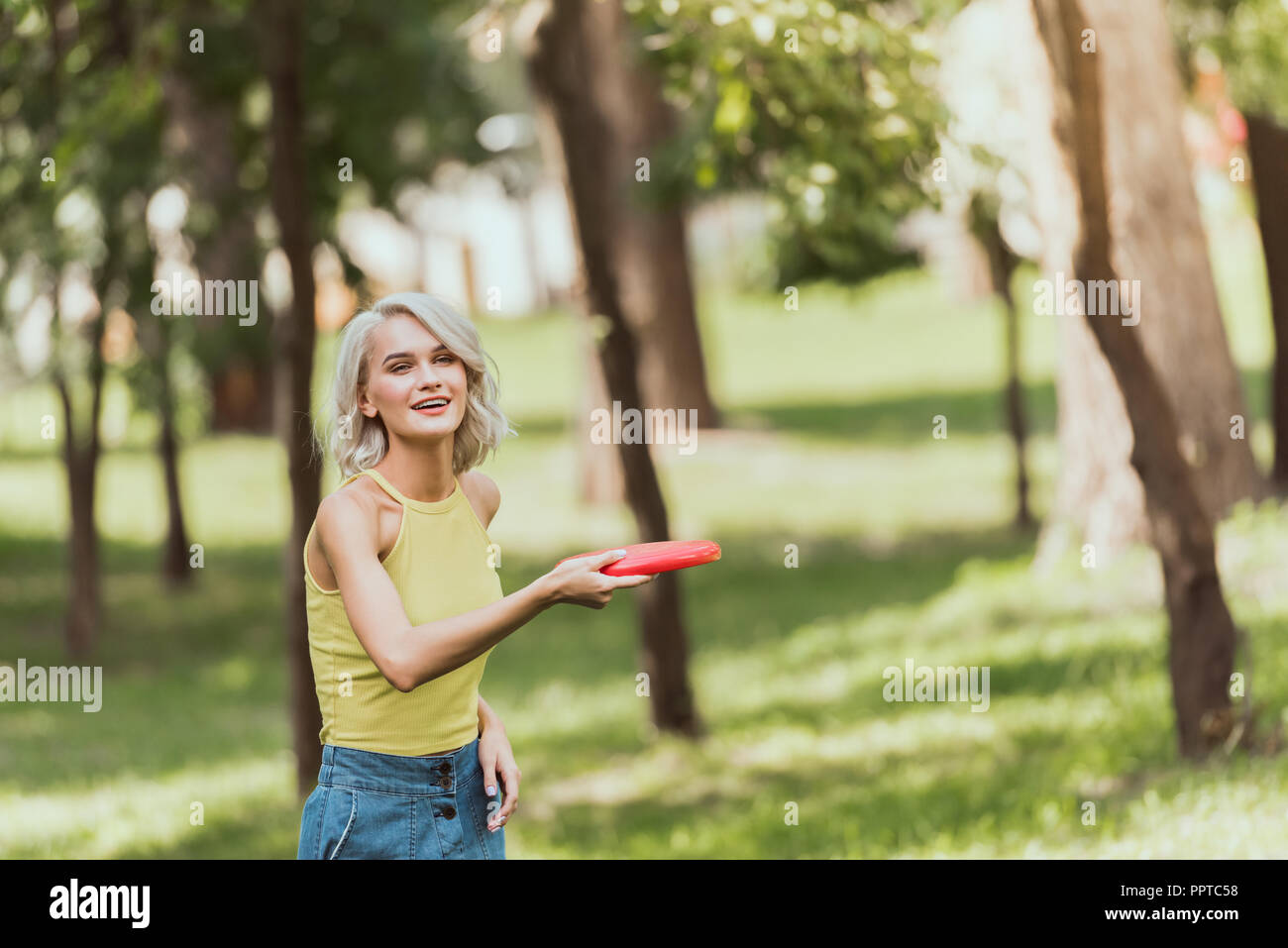 beautiful girl throwing frisbee disk in park Stock Photo - Alamy