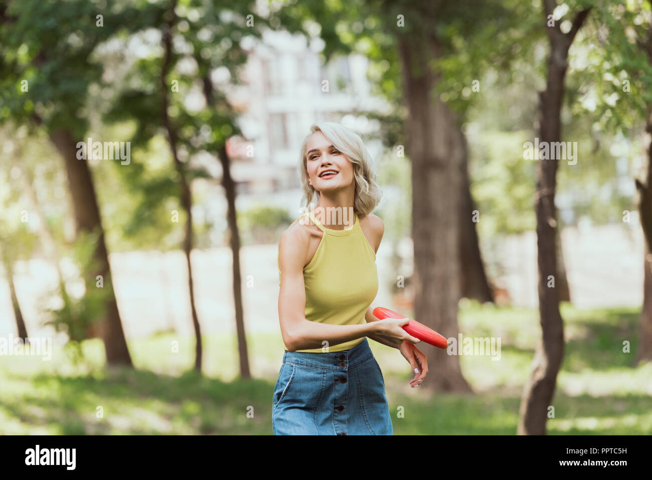 attractive blonde girl throwing frisbee disk in park Stock Photo - Alamy