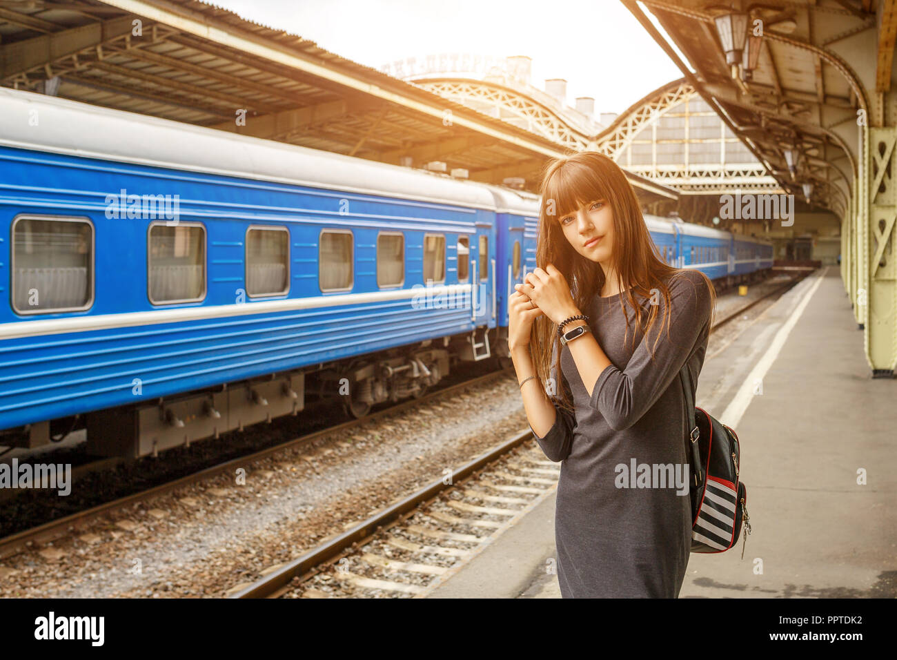 beautiful young woman standing on the platform of the railway station ...