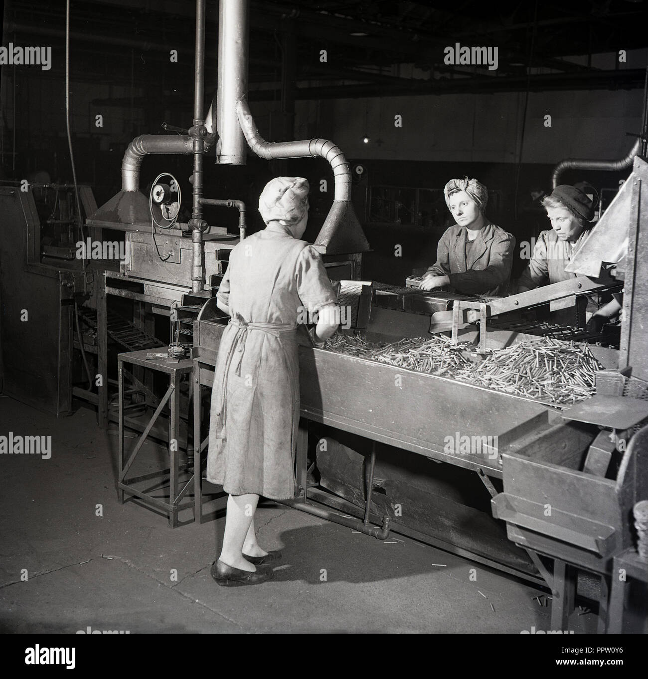 1950s, historical, female factory workers in overalls and hair scarfs ...