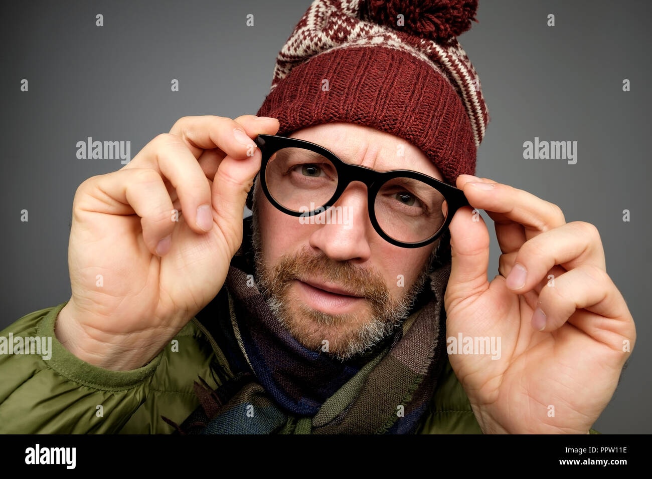 Curious male model with beard looks attentively at one point, sees ...
