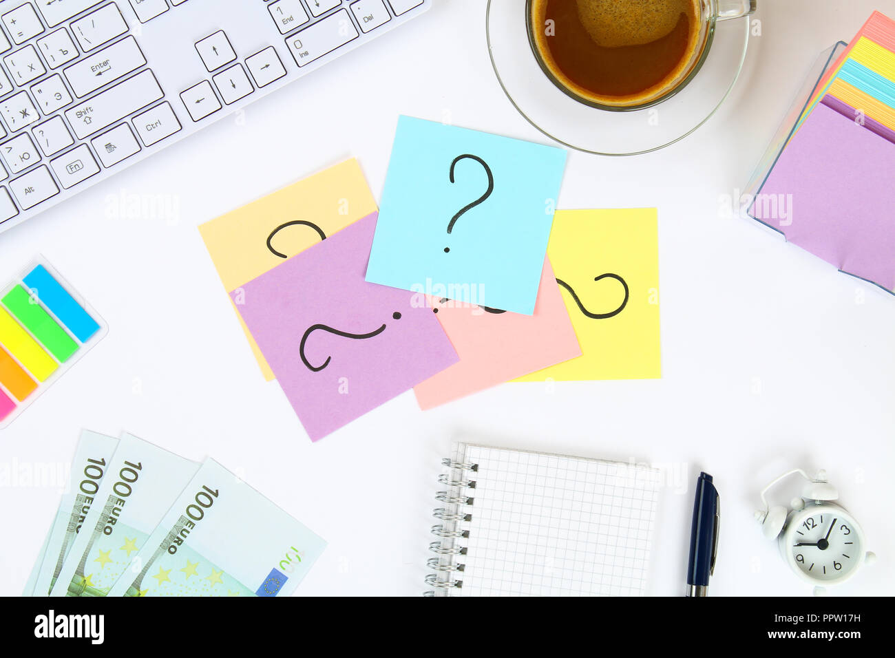 Multicolored stickers note with question mark on white desktop next to ...