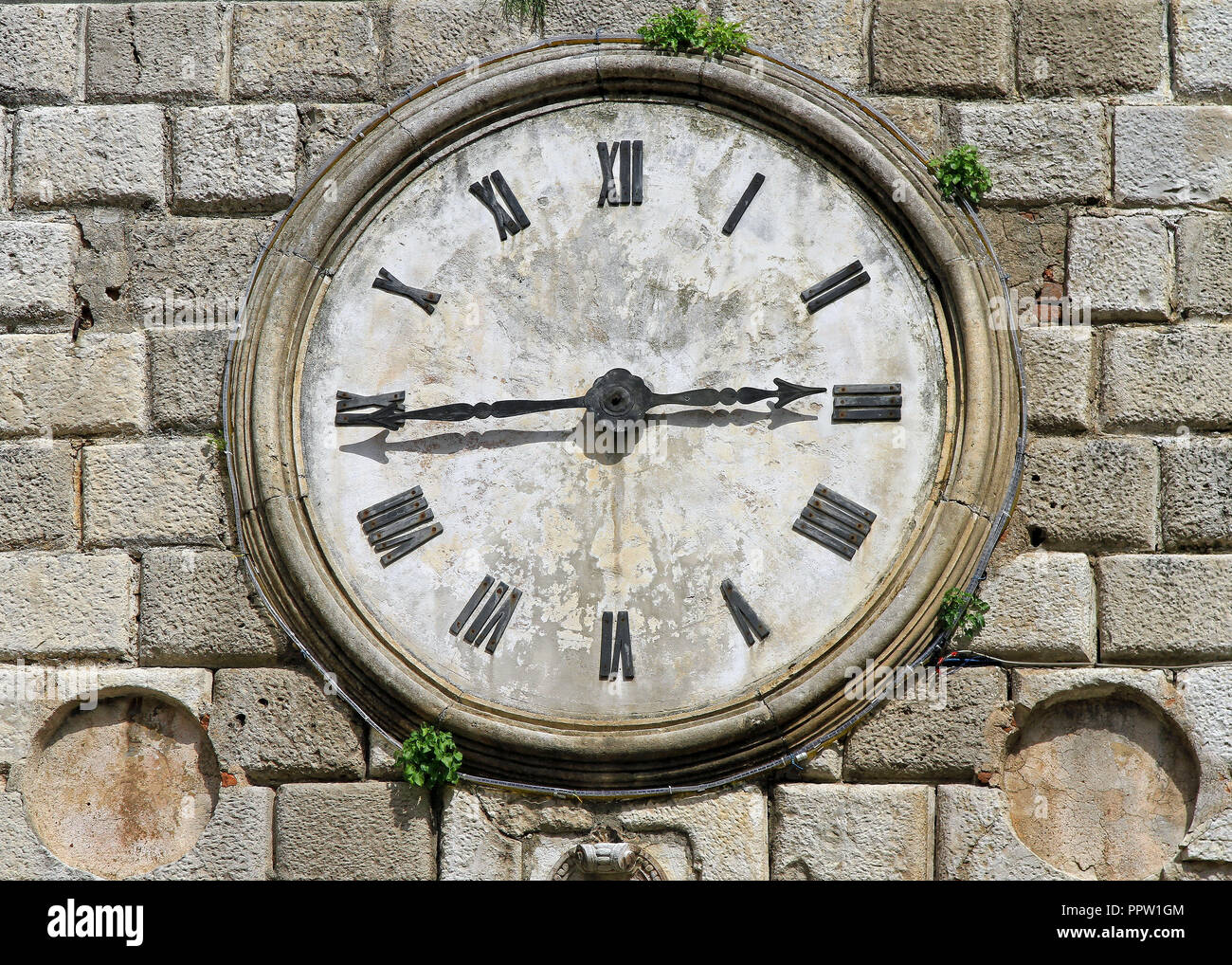 Stone clock at medieval tower in Kotor Stock Photo - Alamy