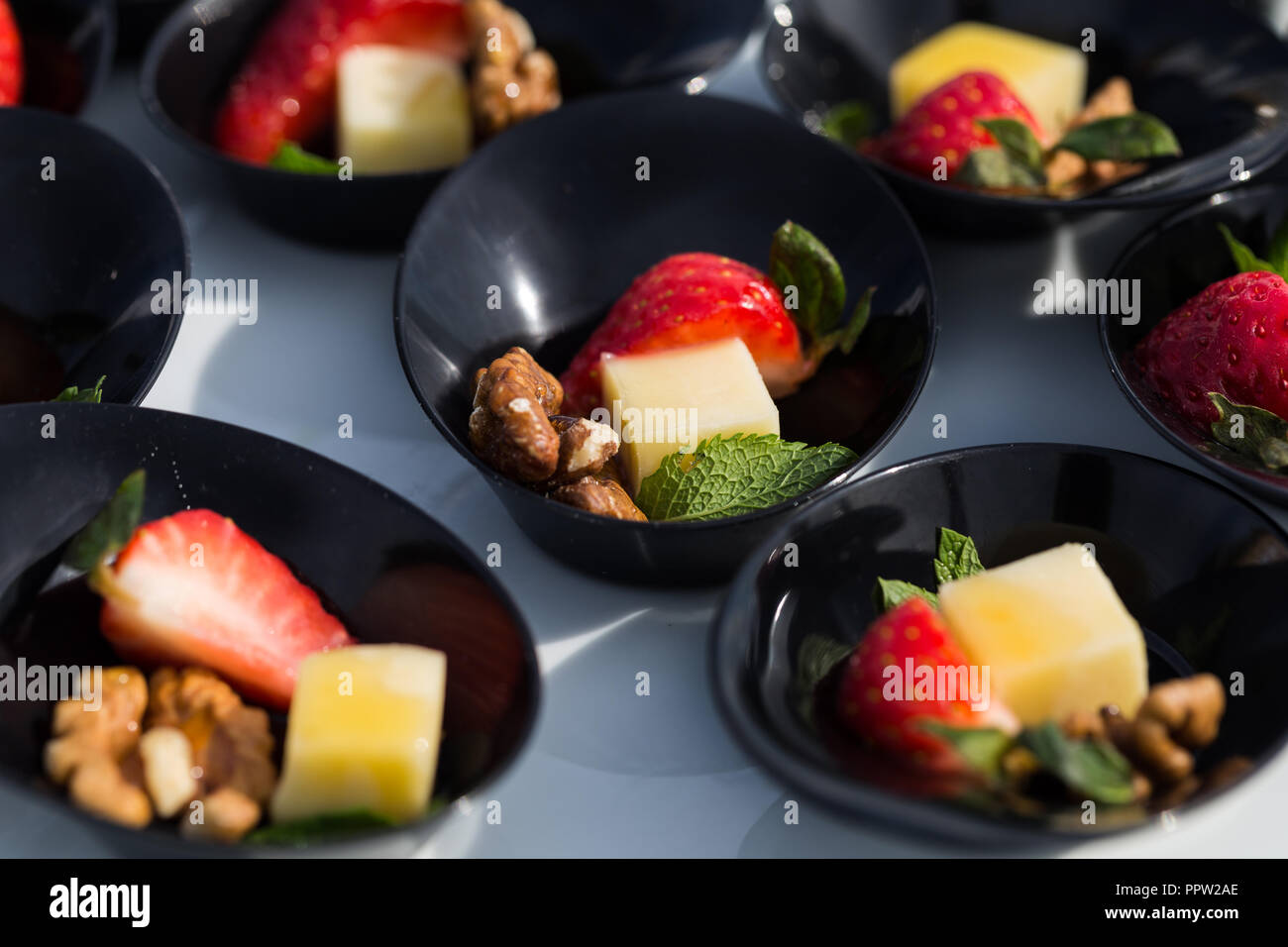 Starting party snack: cheese, strawberry nut and mint Stock Photo - Alamy