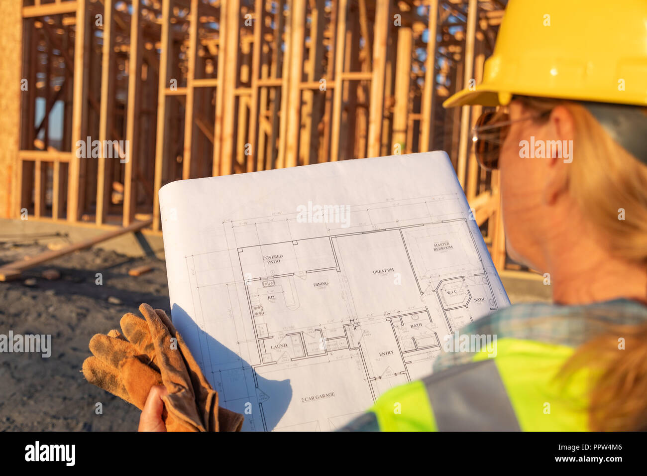 Female Construction Worker with House Plans at Construction Site Stock ...