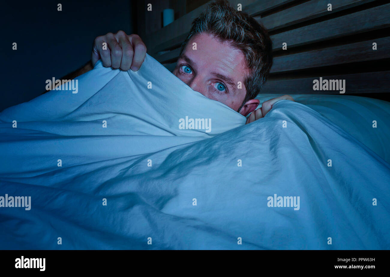 portrait of young attractive scared man in fear and panic suffering ...