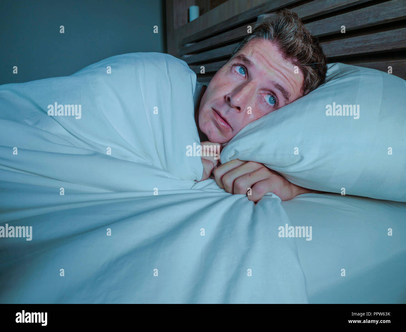 portrait of young attractive scared man in fear and panic suffering ...