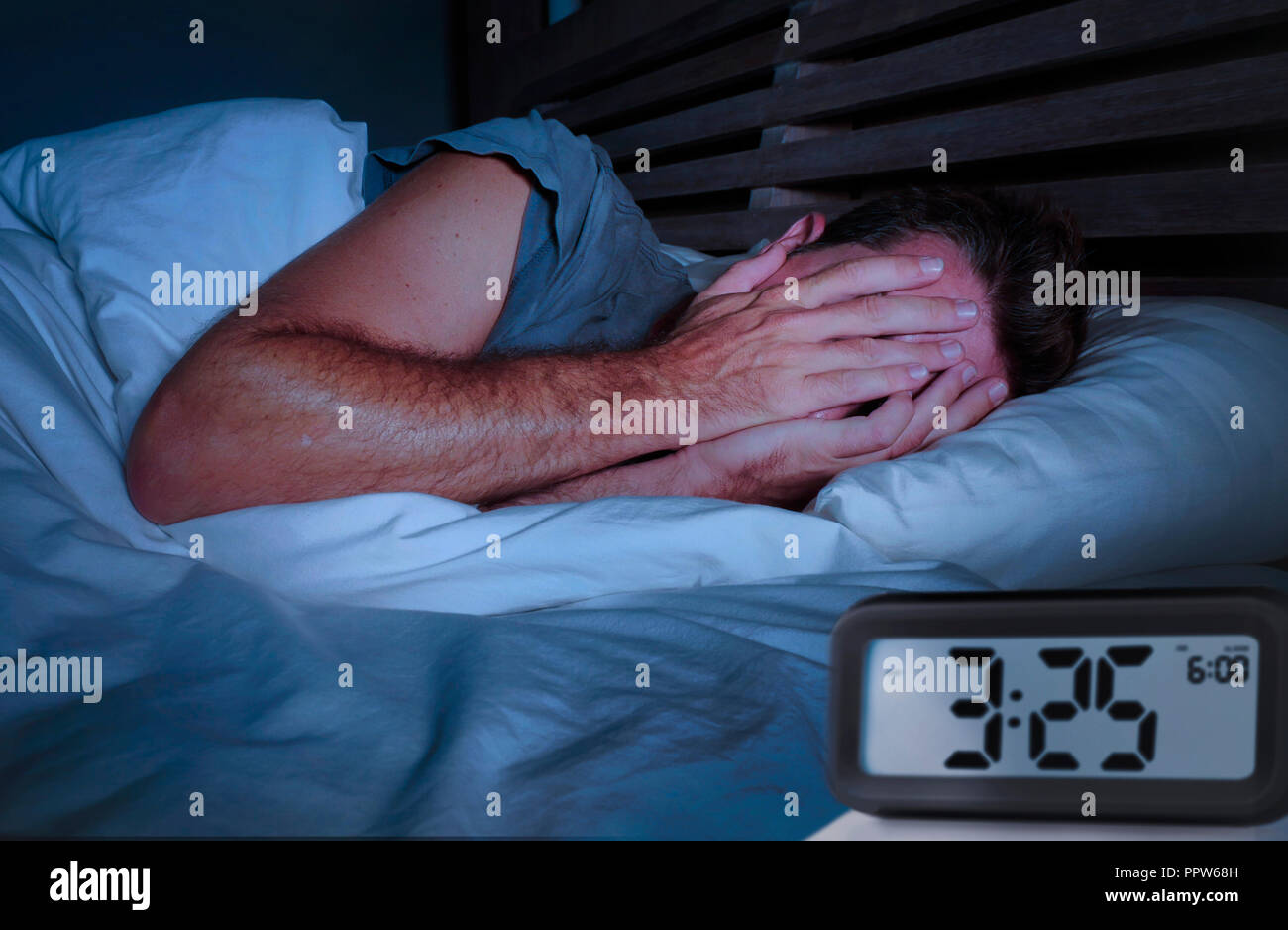 worried sad young attractive man awake lying sleepless on bed covering ...