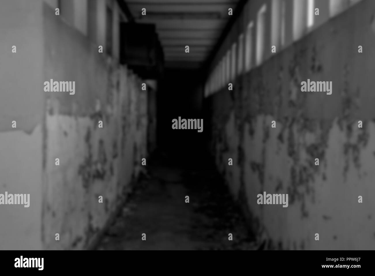 Blurred dark mysterious corridor in building. White wall perspective in ...