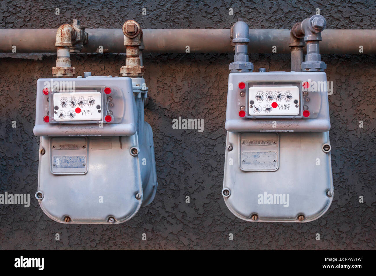 Gas meters with pipe and textured wall Stock Photo - Alamy