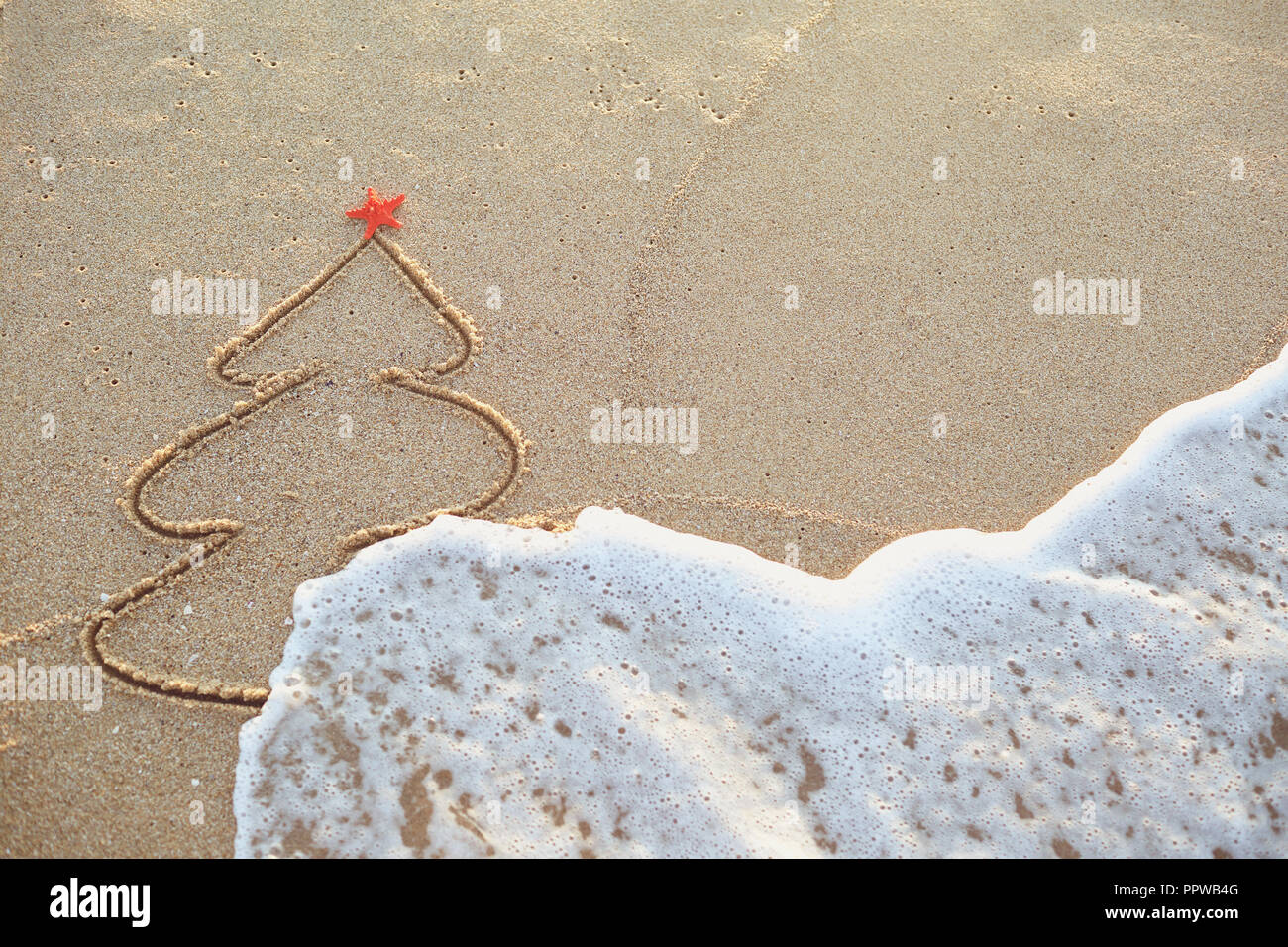 Painted Christmas tree in the sand on the beach Stock Photo - Alamy