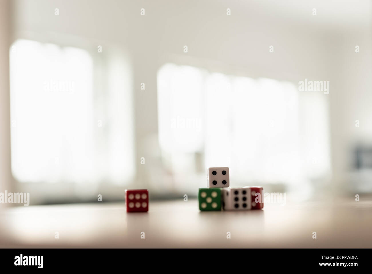 Gaming dice stacked on desk in a bright office Stock Photo - Alamy