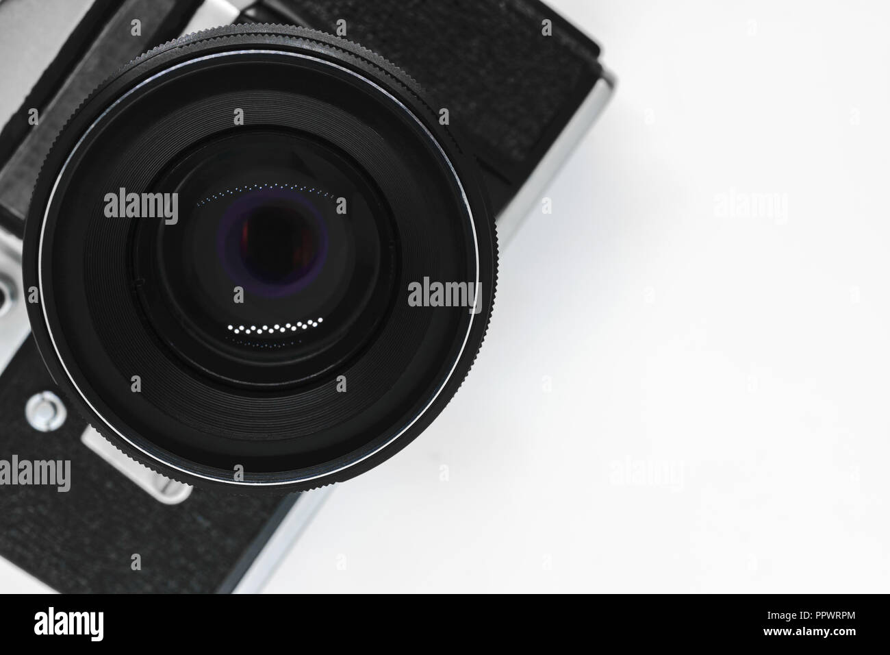 Very old vintage SLR black photo camera with black lens view from top ...