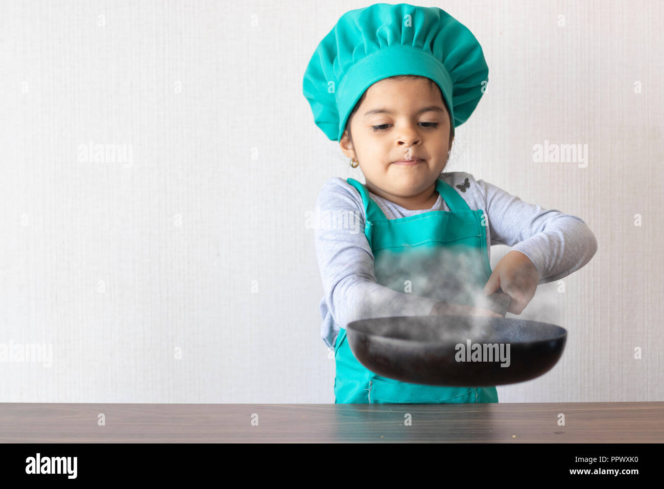 Cute little girl cooking with her frying pan in the kitchen Stock Photo ...