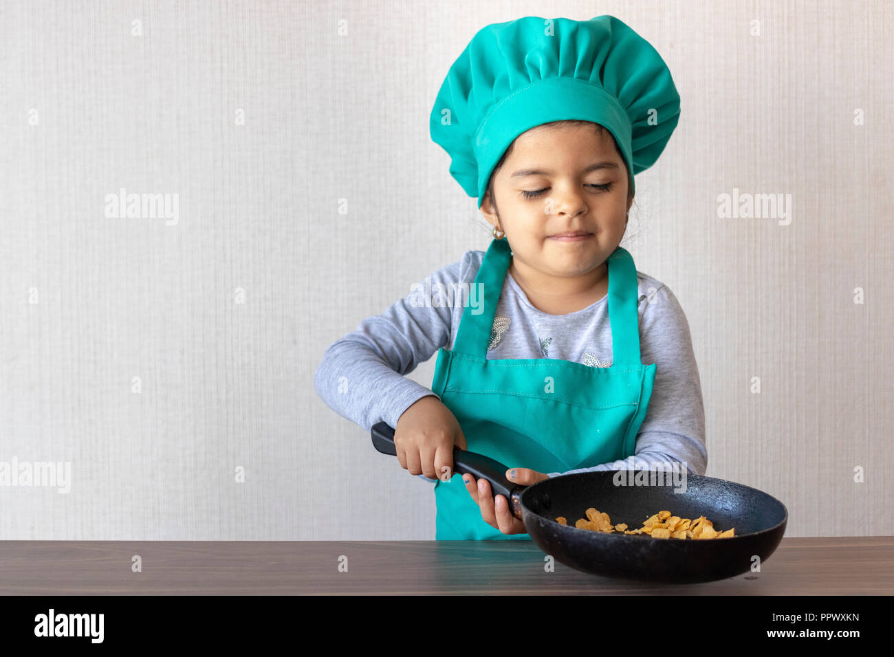 Cute little girl cooking with her frying pan in the kitchen Stock Photo ...