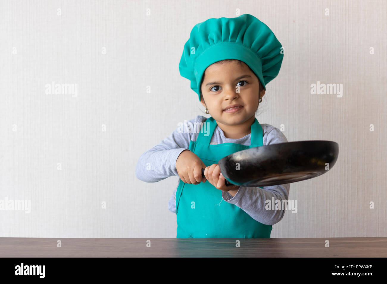 Cute little girl cooking with her frying pan in the kitchen Stock Photo ...