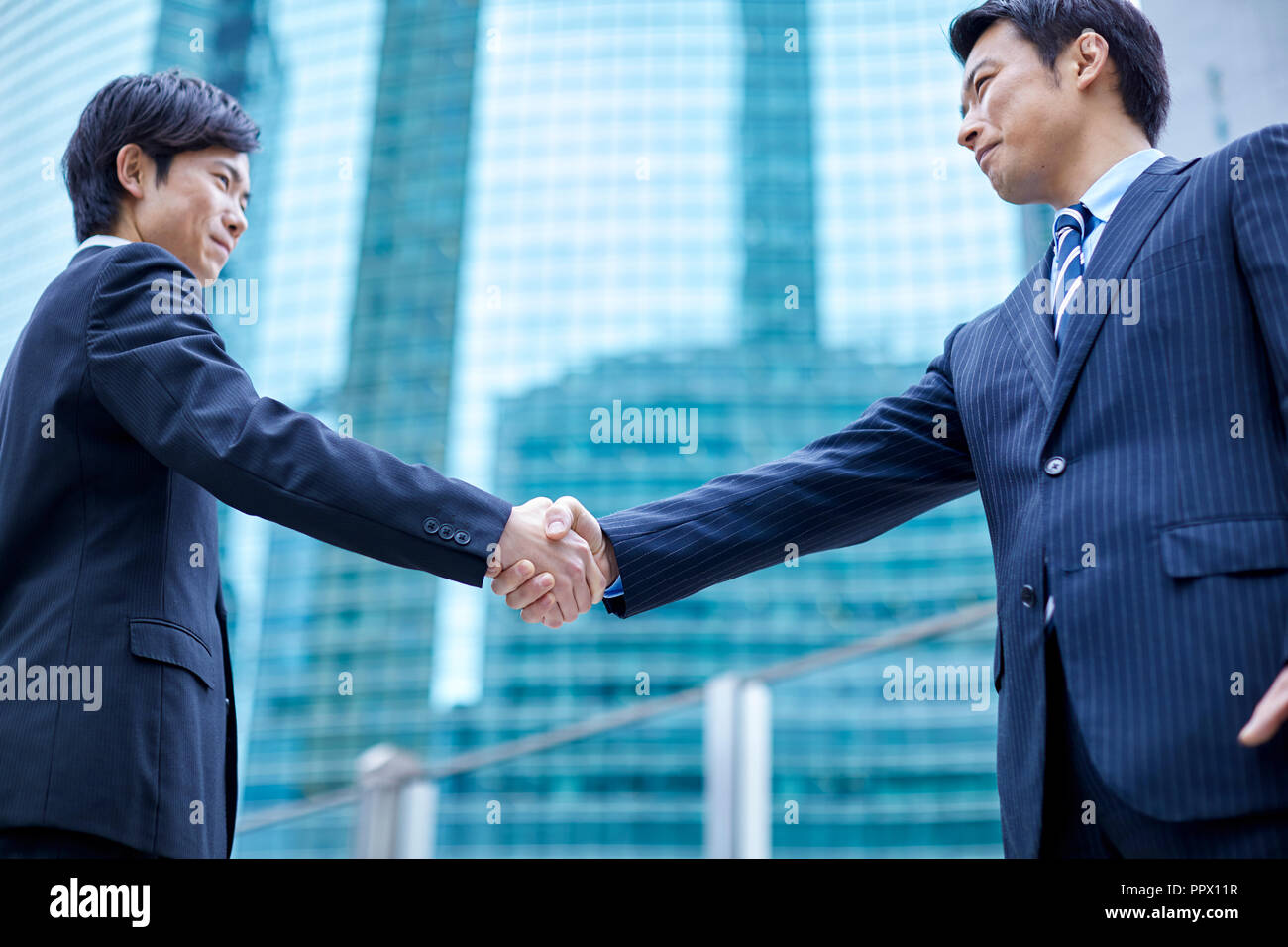 Japanese businesspeople shaking hands downtown Tokyo Stock Photo - Alamy