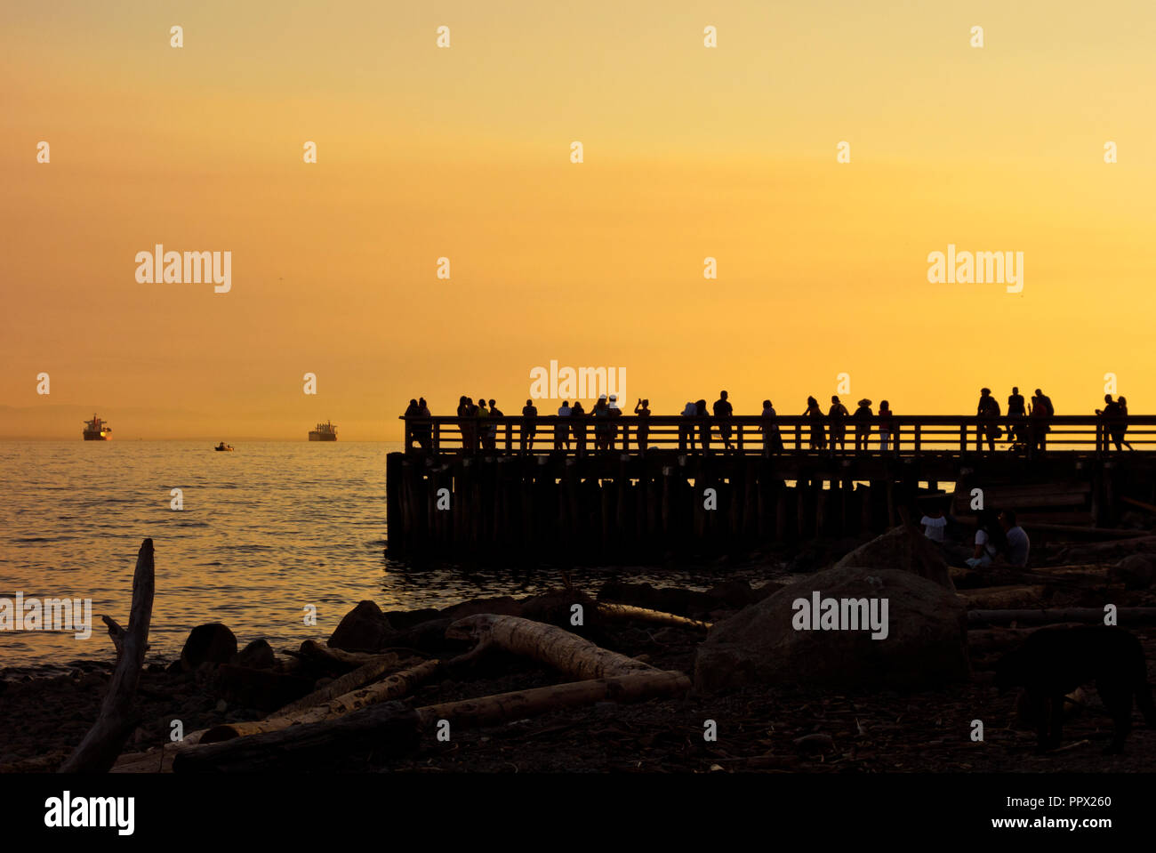 Silhouettes of people on the pier at sunset in Ambleside in West ...