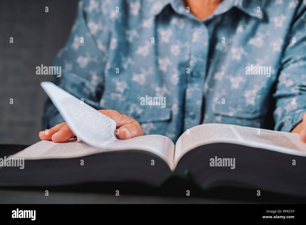 Old woman flipping through pages of book. Grandmother with Bible ...