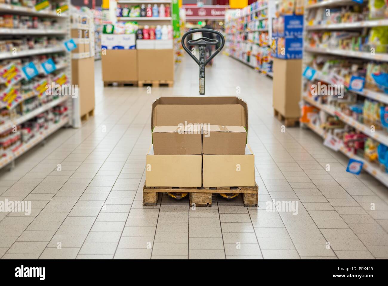 Pallet truck with carton boxes in supermarket store Stock Photo - Alamy