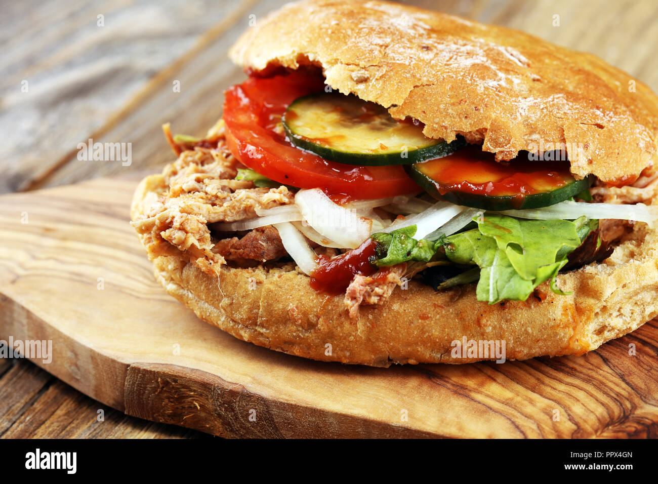 Pulled pork sandwiches with BBQ sauce, cabbage and pickles on wooden ...