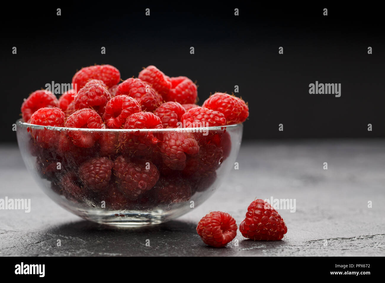 Photo of raspberries in transparent glass cup Stock Photo - Alamy