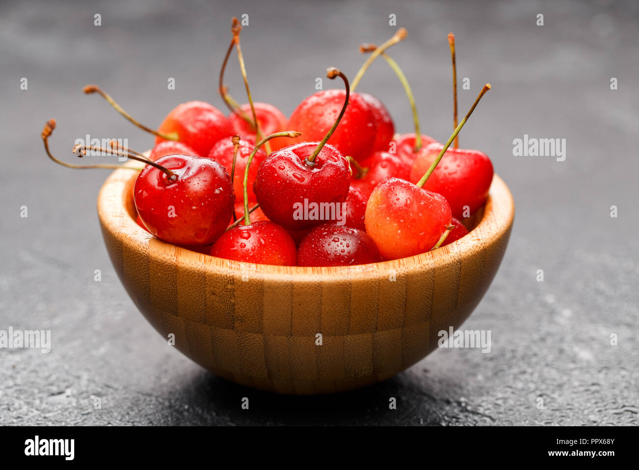 Photo of red cherry in wooden cup Stock Photo - Alamy
