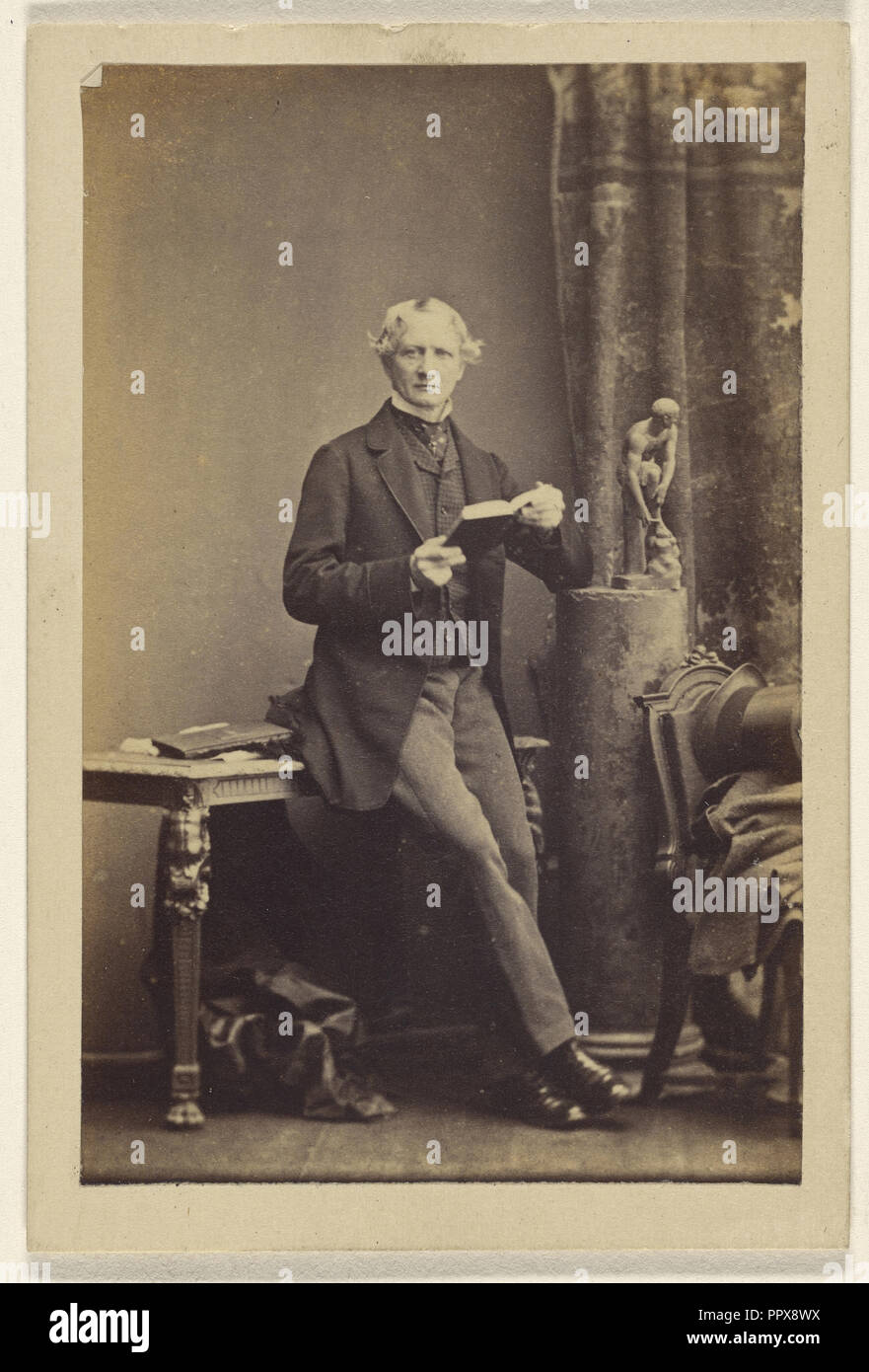 man seated on table, holding an opened book; Camille Silvy, French ...