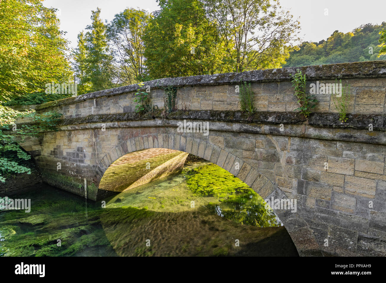 Old stone bridge across a stream in morning light in Arundel, West ...