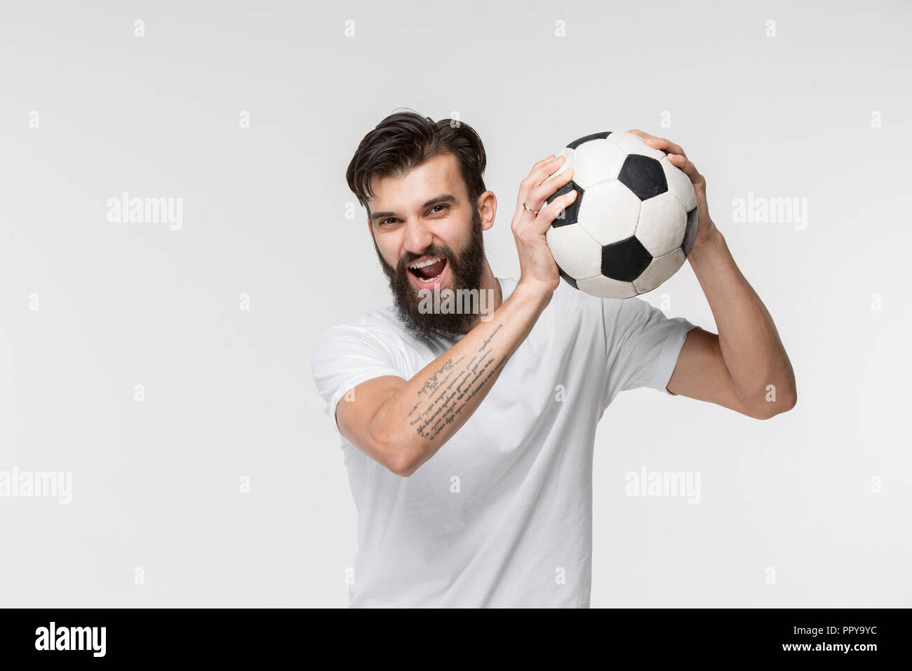 Young soccer player with ball in front of white studio background Stock ...