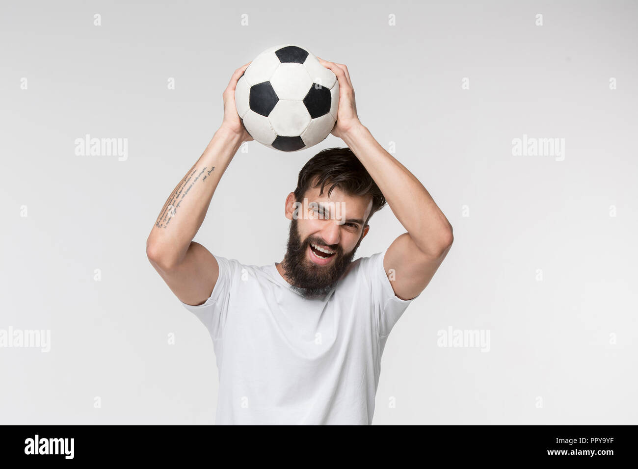 Young soccer player with ball in front of white studio background Stock ...