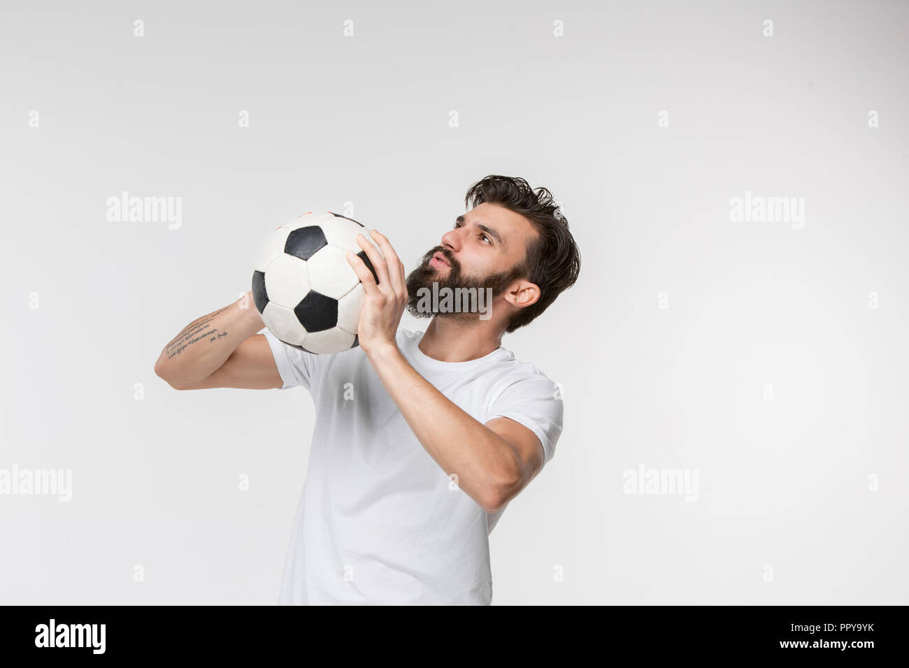 Young soccer player with ball in front of white studio background Stock ...