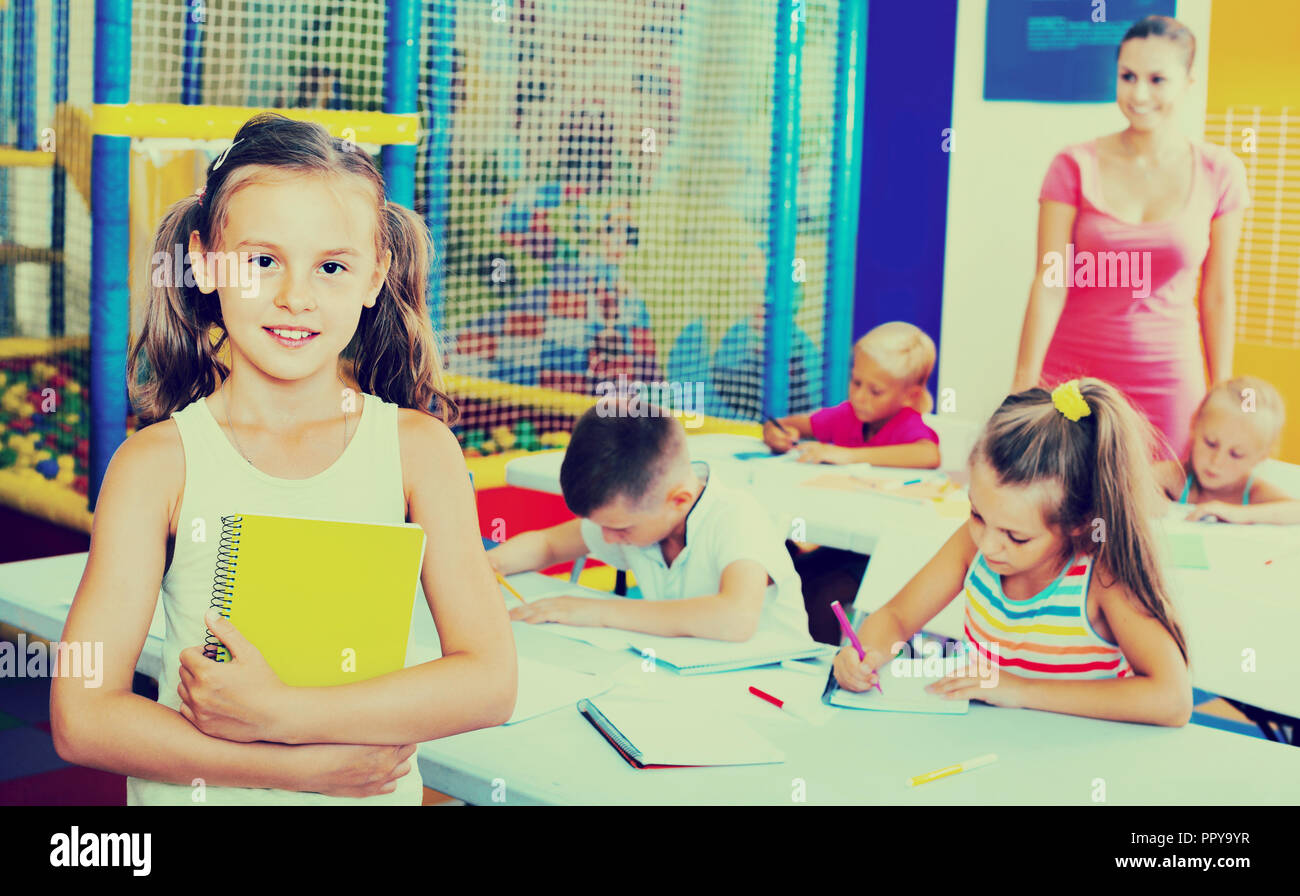 Portrait of cheerful diligent pupil girl studying in school class Stock ...
