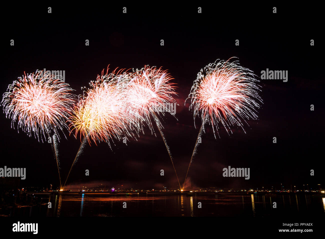 Germany, Impressive giant red firework fireballs over silent lake water ...