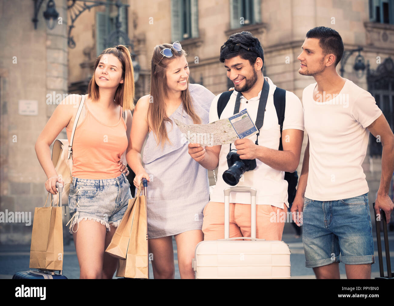 young people tourists searching for direction using paper map in town ...