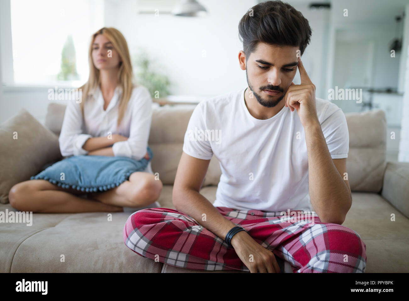 Worried couple having problems in bedroom Stock Photo - Alamy