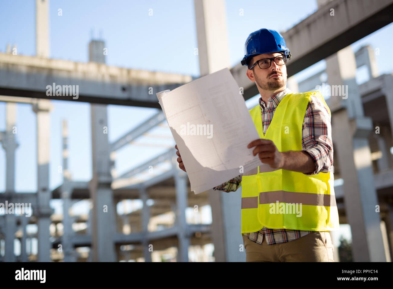 Picture of construction site engineer looking at plan Stock Photo - Alamy